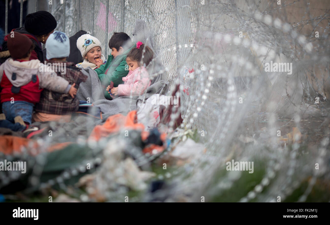 Refugee children lying by the border fence in the refugee camp near the ...