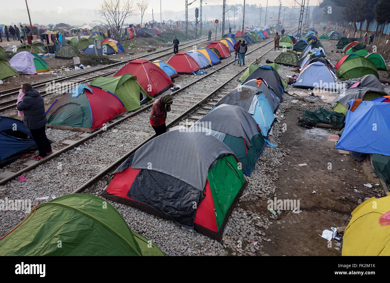 Refugees sitting outside their tents in the refugee camp near the Greek ...