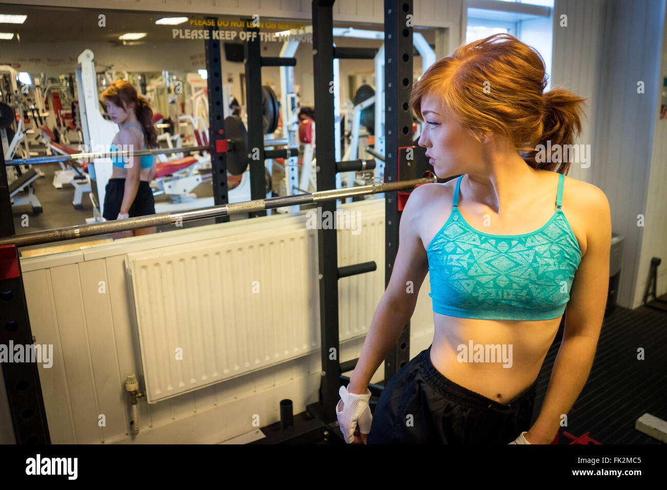 Young and beautiful female fitness competitor on a squats rack Stock ...