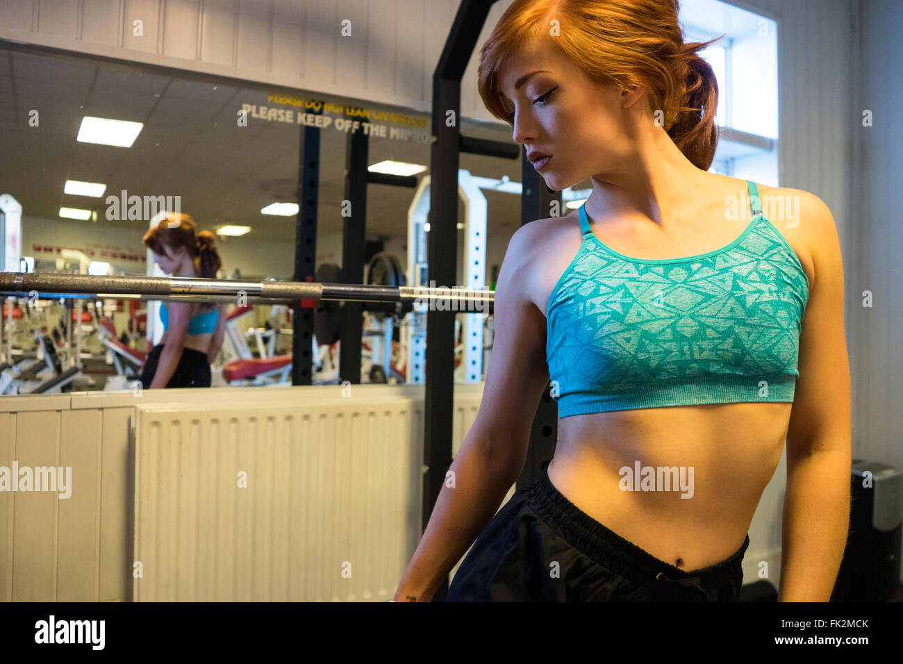 Young and beautiful female fitness competitor on a squats rack Stock ...