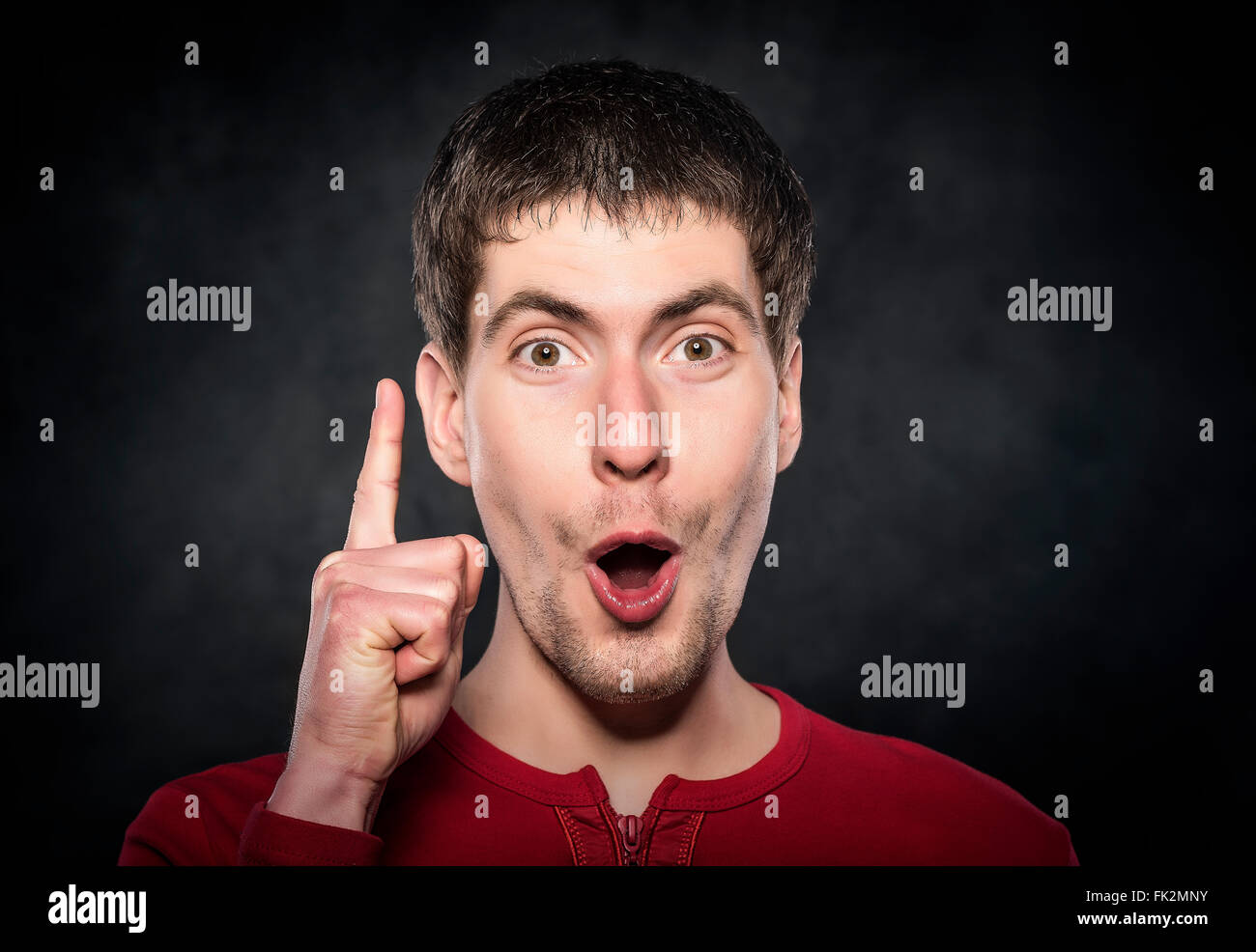 Young man shows finger up Stock Photo - Alamy