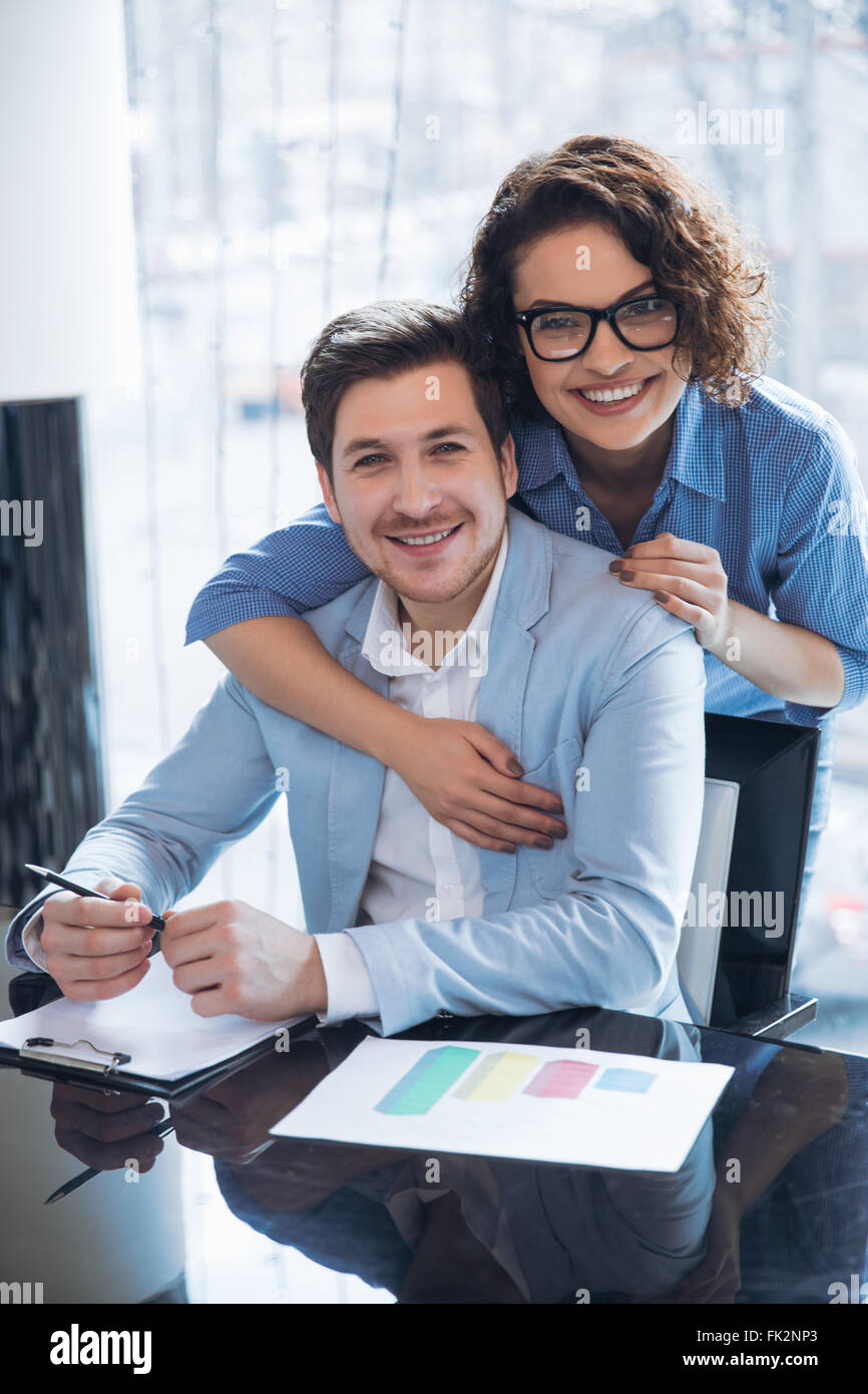 Pleasant colleagues embracing Stock Photo - Alamy