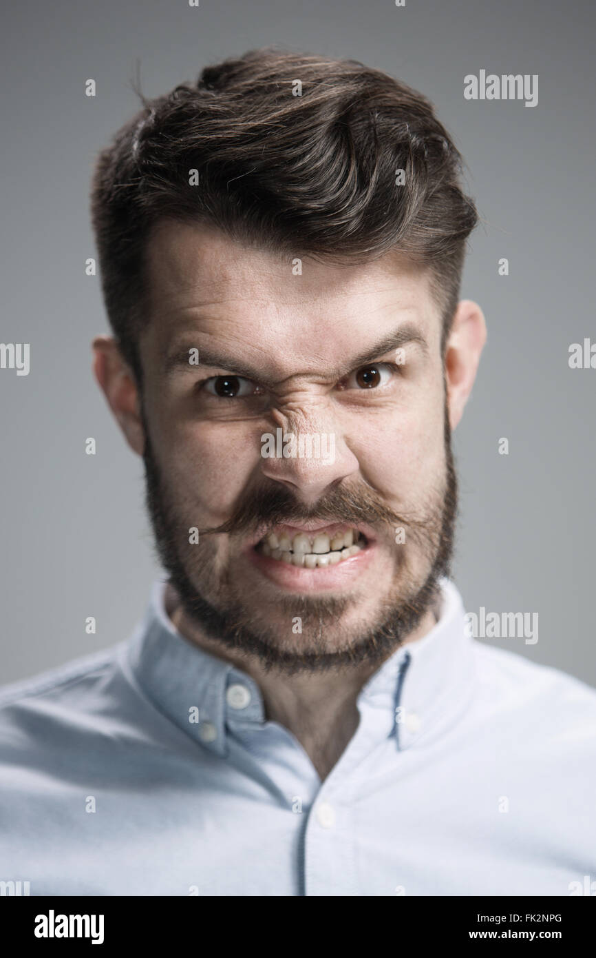 Close up of face of angry man on gray background Stock Photo - Alamy
