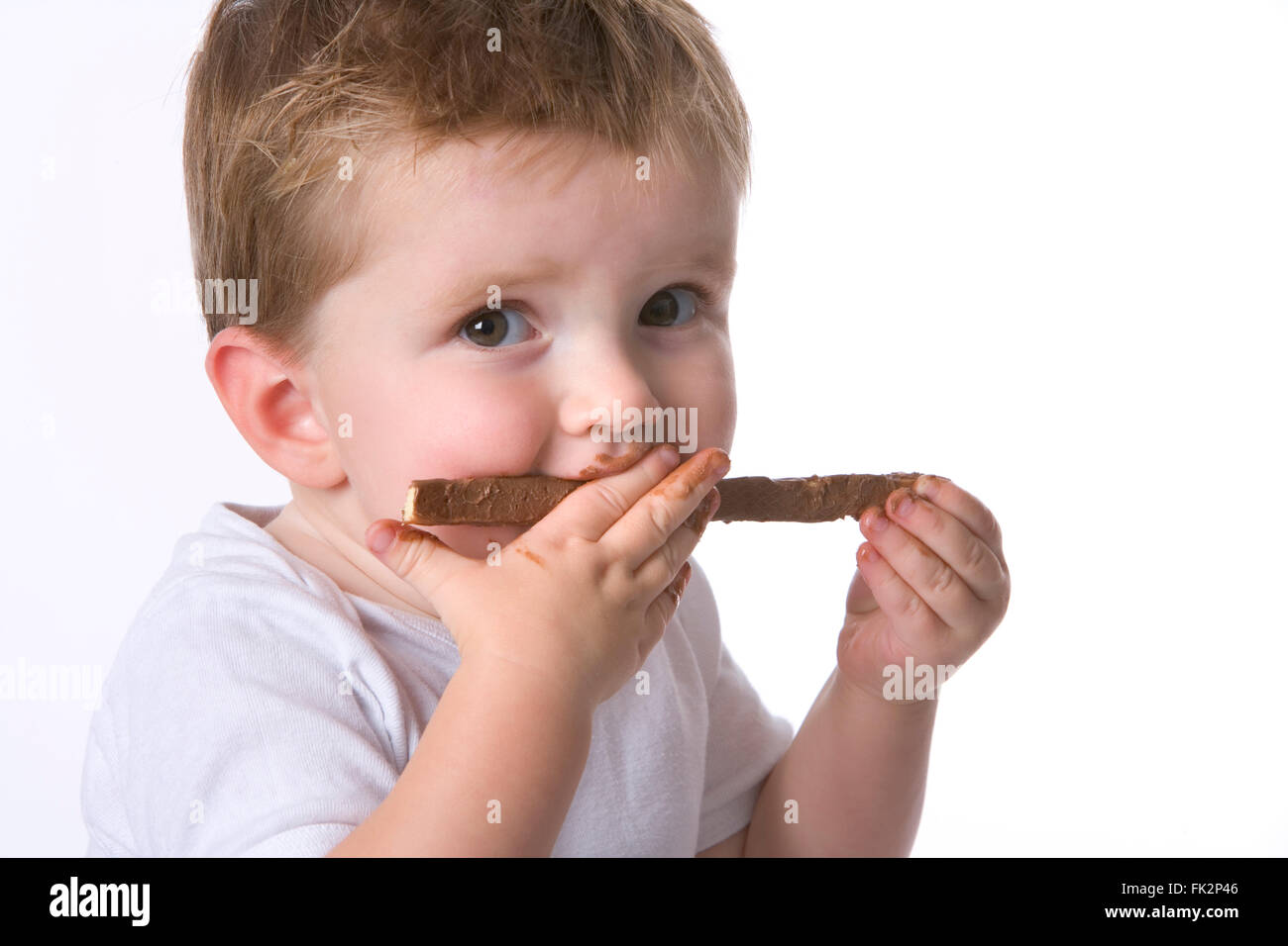 Little Toddler Boy Is Eating A Chocolate Snack on white background ...