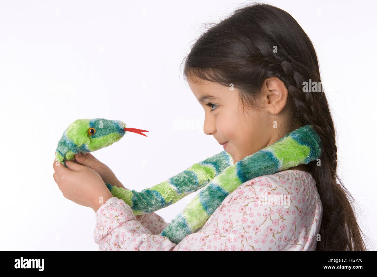 Little Girl Is Talking To A Toy Snake on white background Stock Photo ...