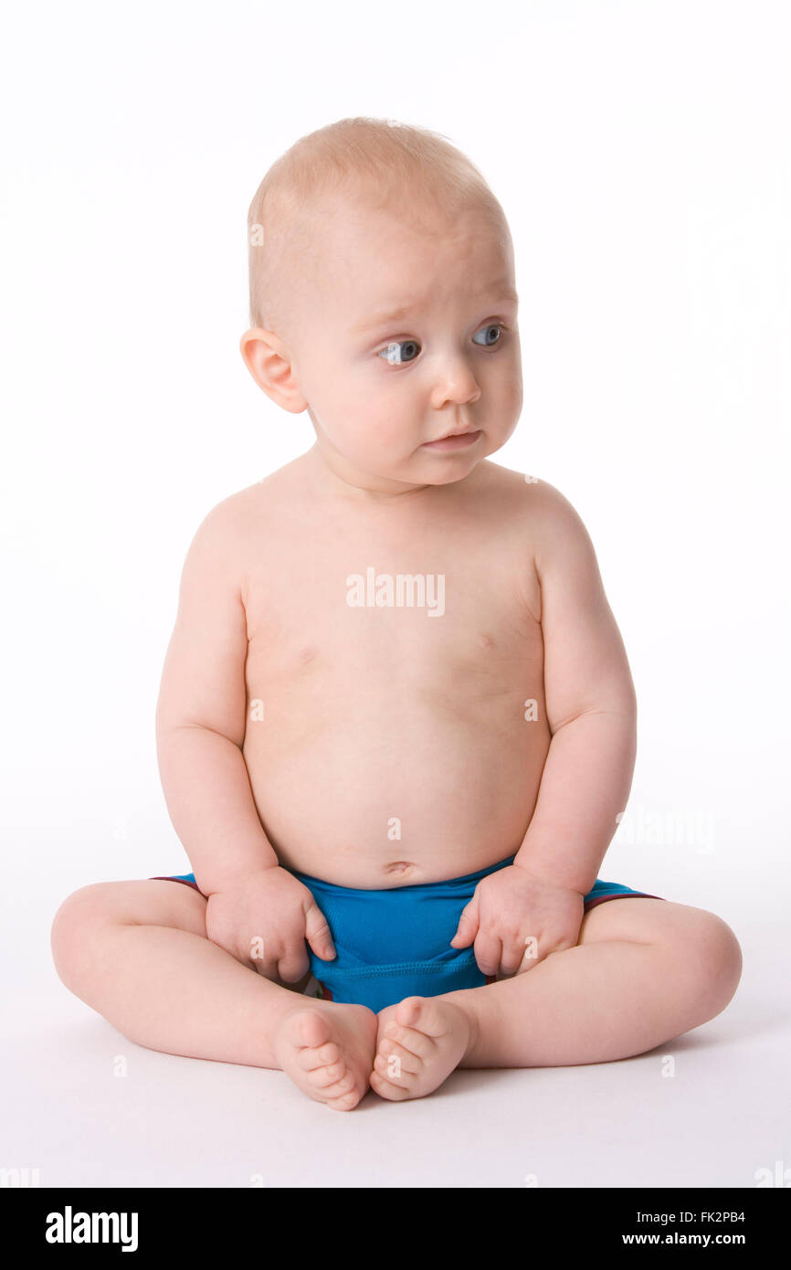 Little baby boy sitting on the floor with a suspicious expression on ...