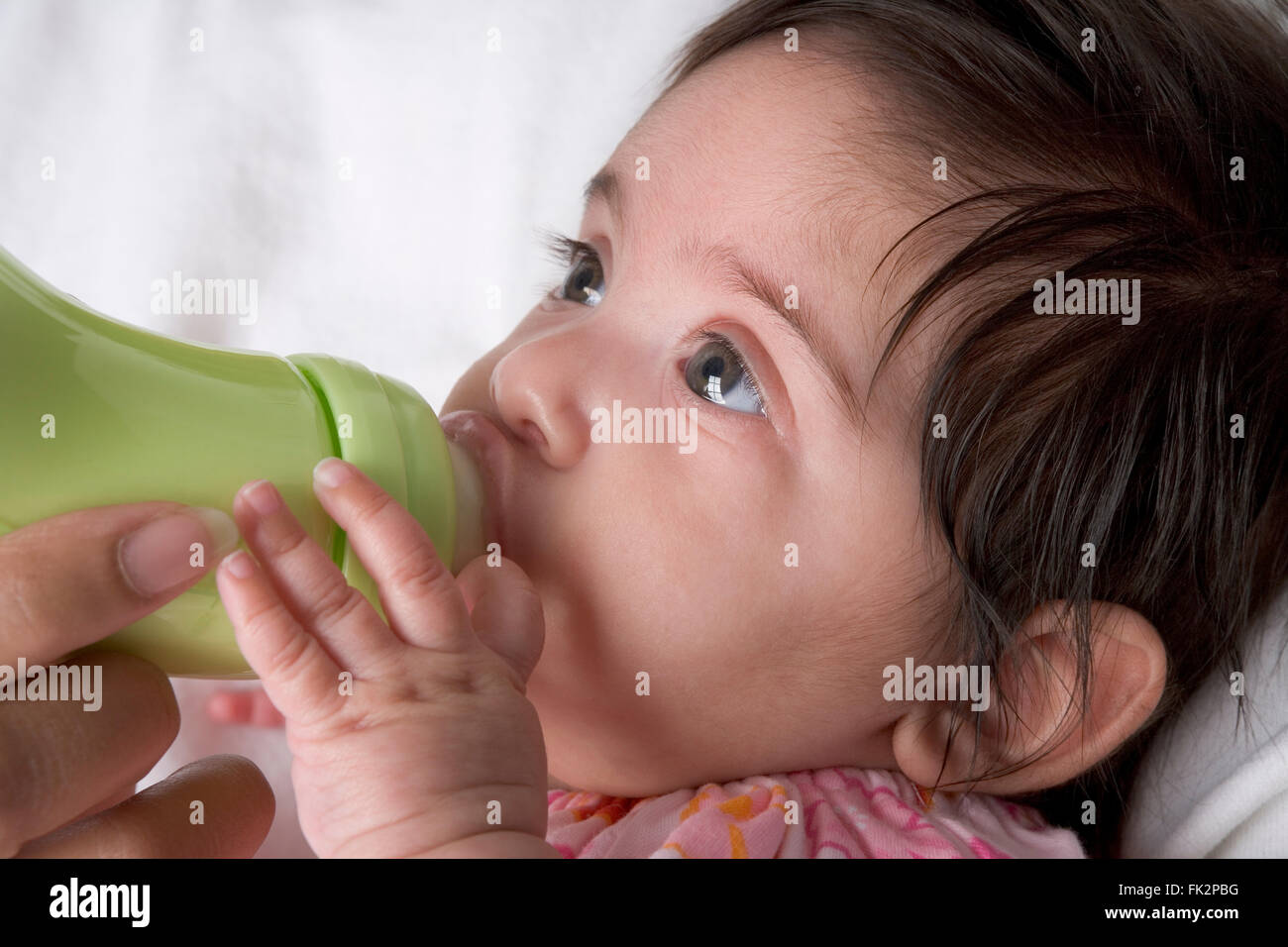 Baby Girl Is Drinking From A Baby-bottle Stock Photo - Alamy