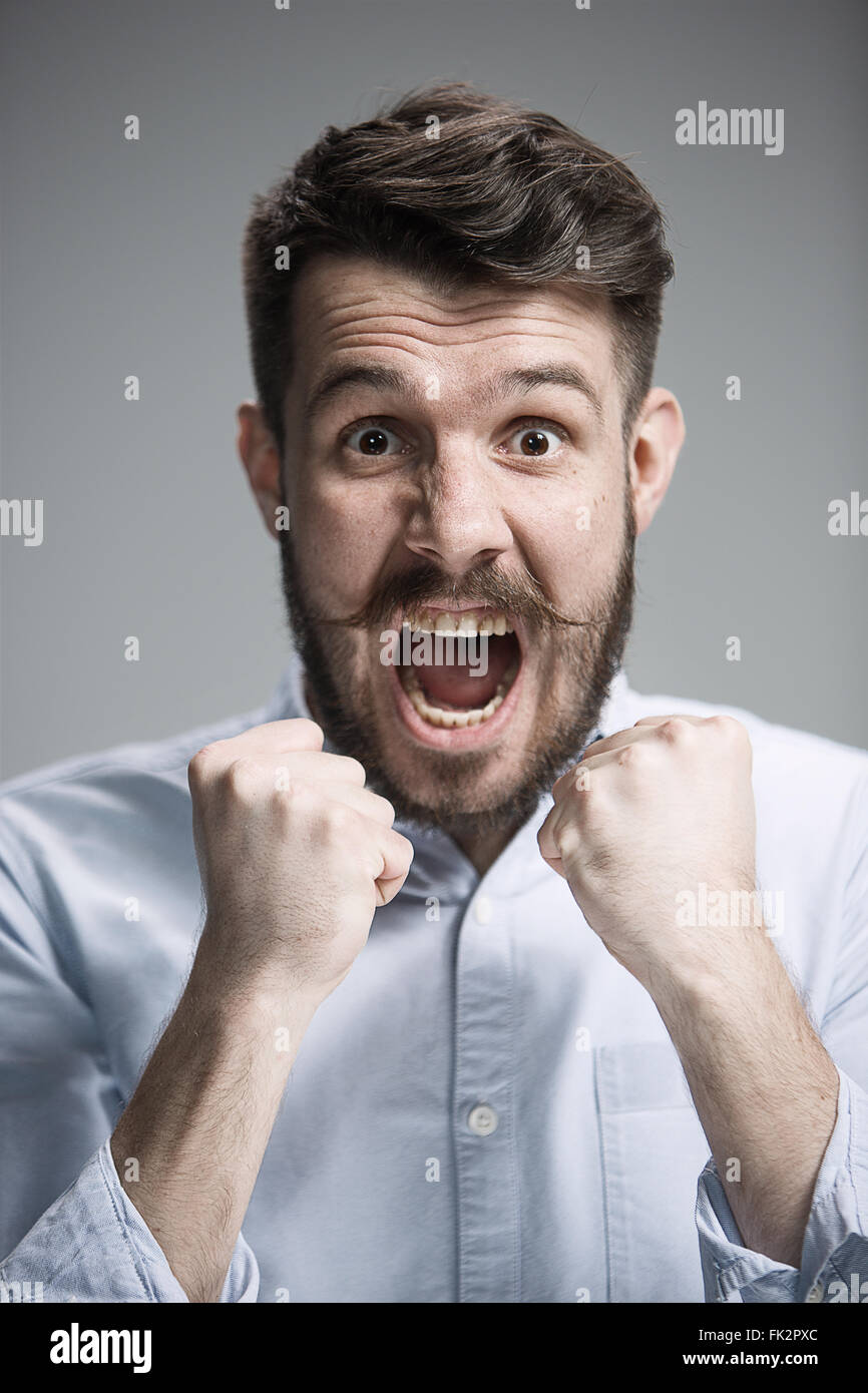Close up of face of angry man on gray background Stock Photo - Alamy