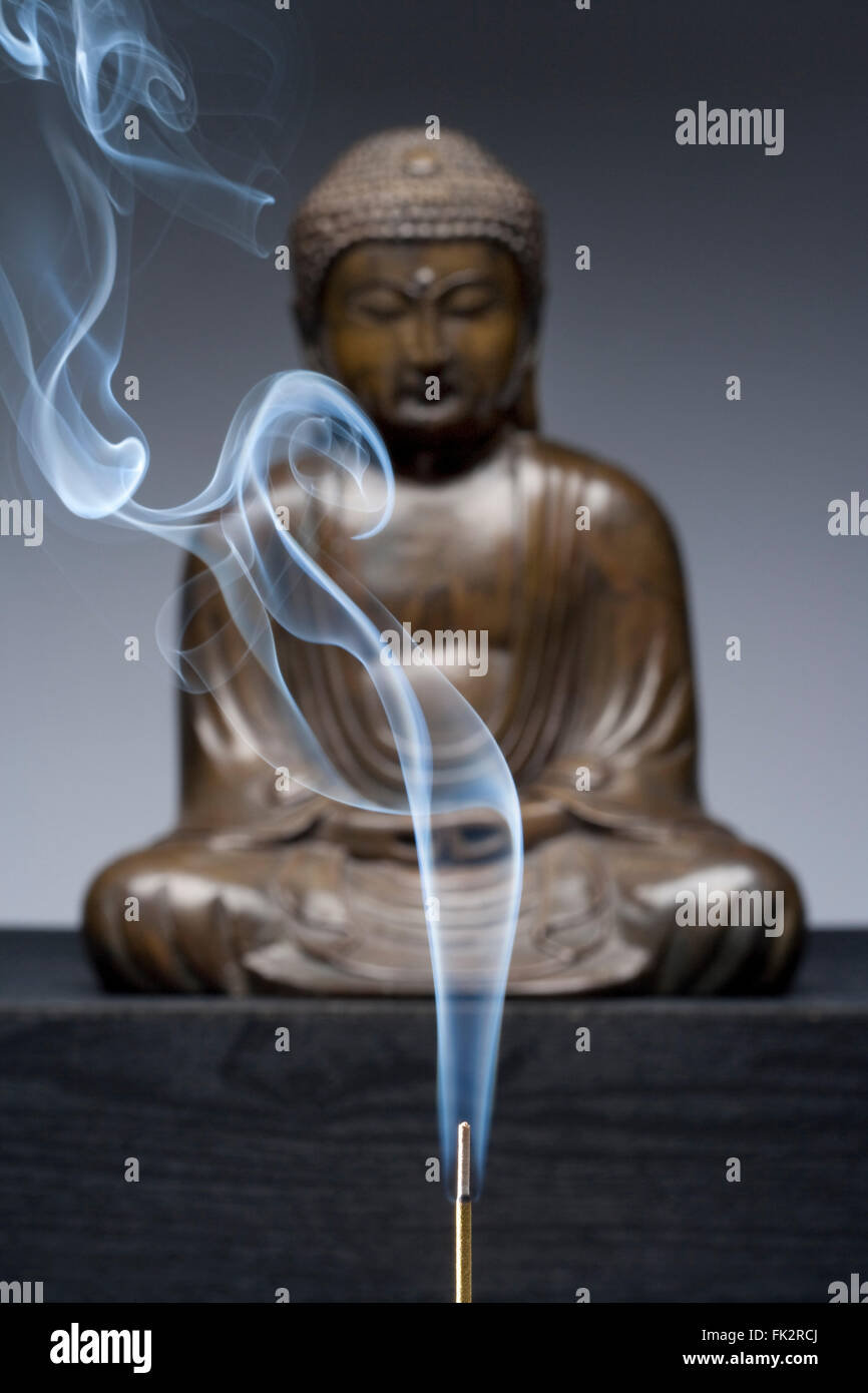 Bronze Buddha Statue With Burning Incense Smoke Stock Photo - Alamy