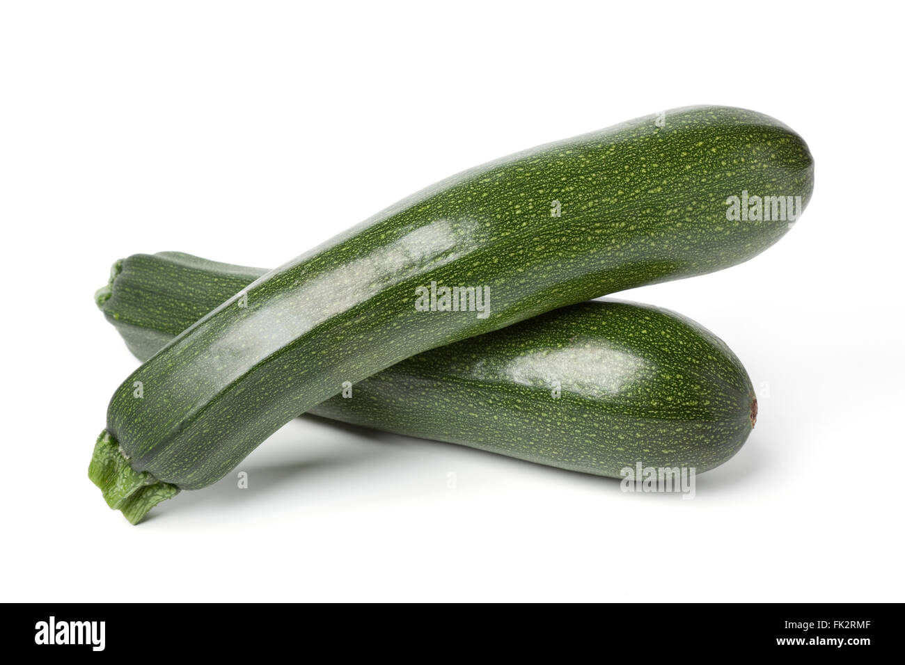 Two fresh whole courgettes on white background Stock Photo - Alamy