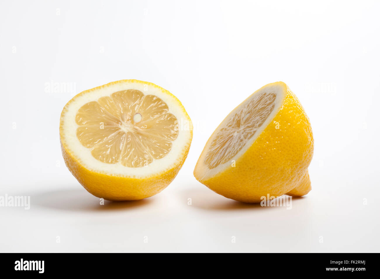 Two half fresh lemons on white background Stock Photo - Alamy