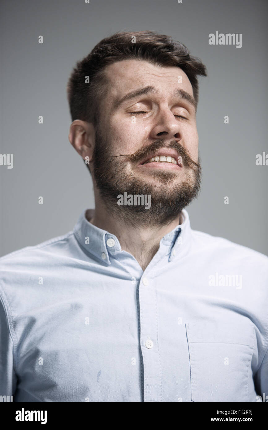 The crying man with tears on face closeup on blue background Stock ...