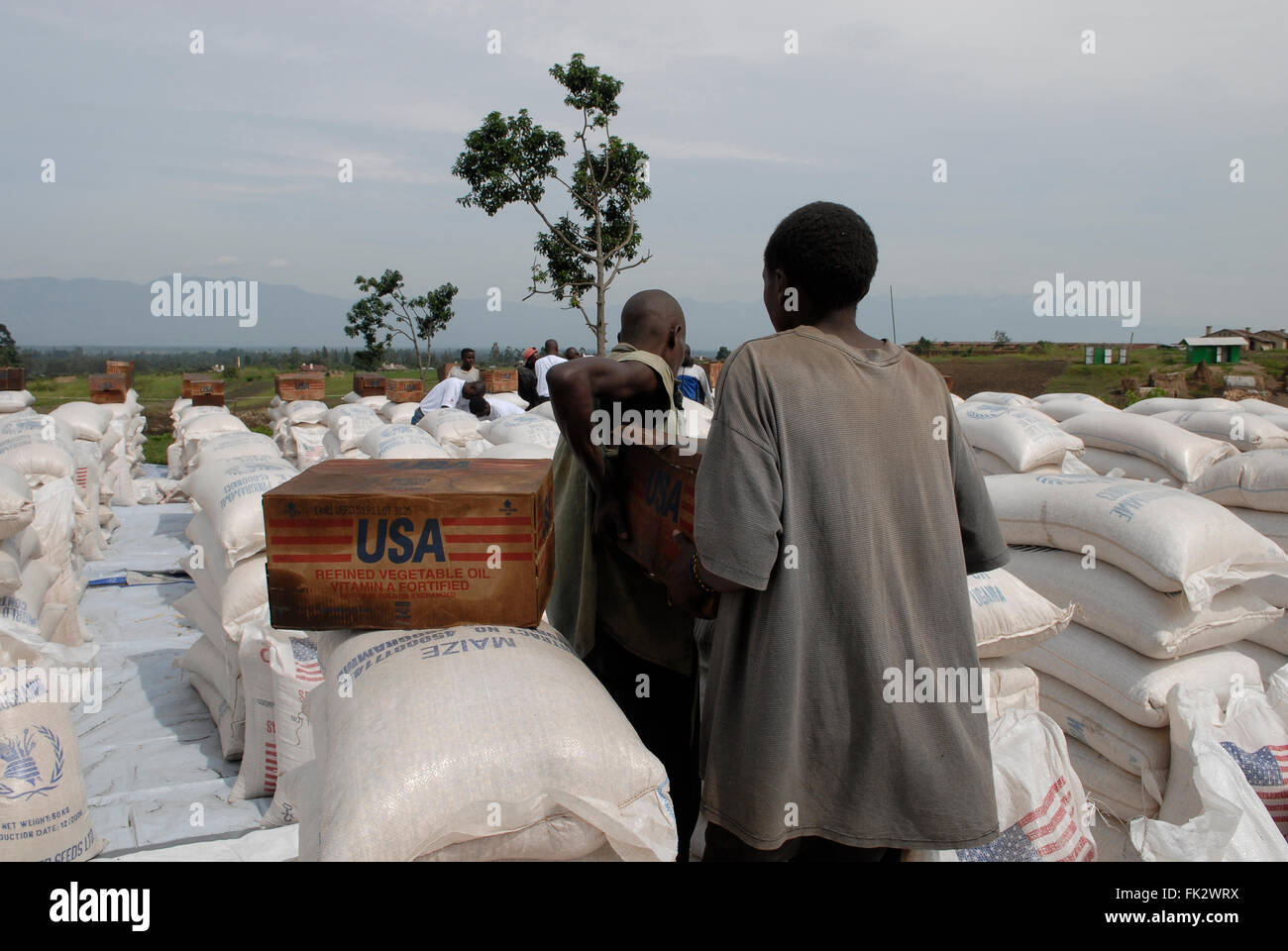 Local men carrying boxes of refined vegetable oil donated by USAID ...