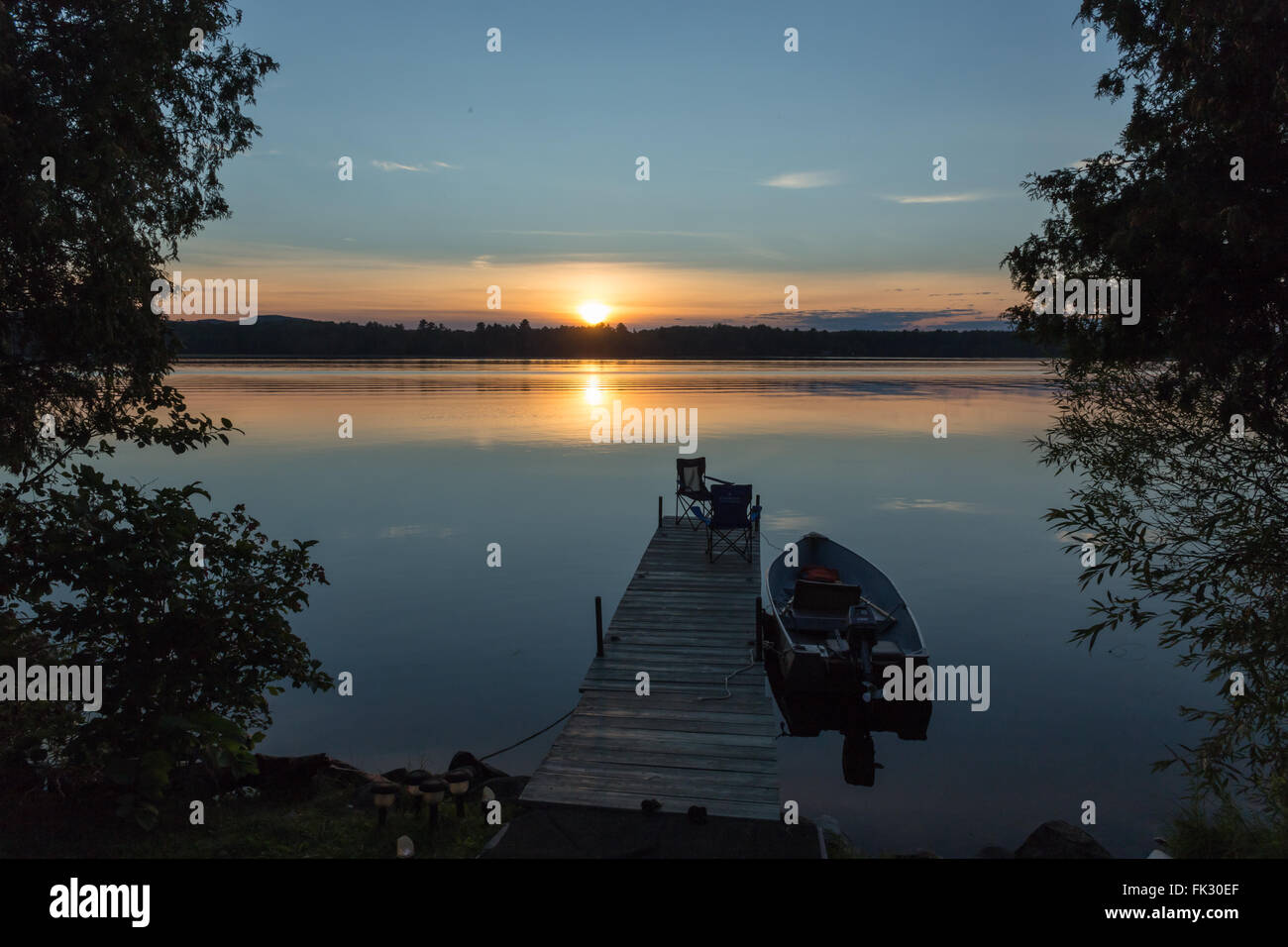 Sunset over a lake or river Stock Photo - Alamy