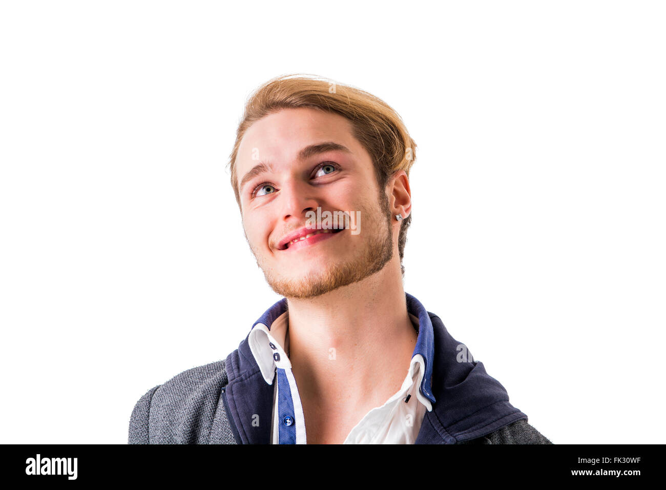 Attractive young man thinking, looking up with hand on his chin ...