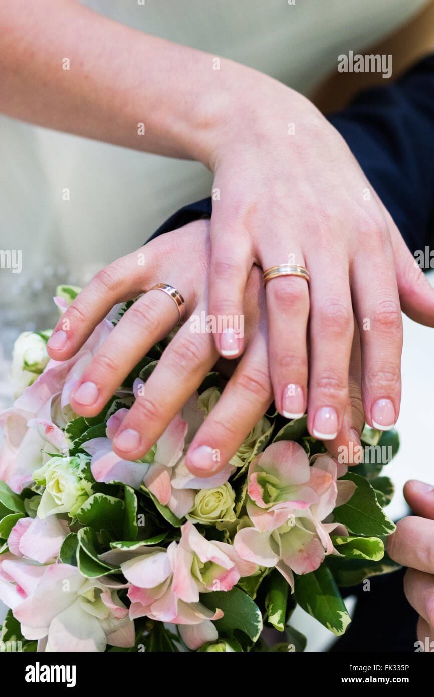 Hands and rings of just married on wedding bouquet Stock Photo - Alamy