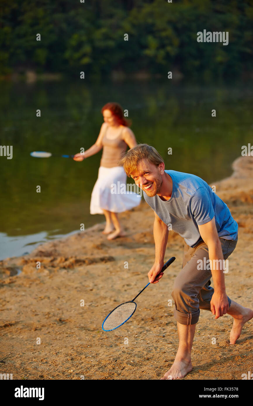 Happy people playing badminton together on vacation at beach Stock ...