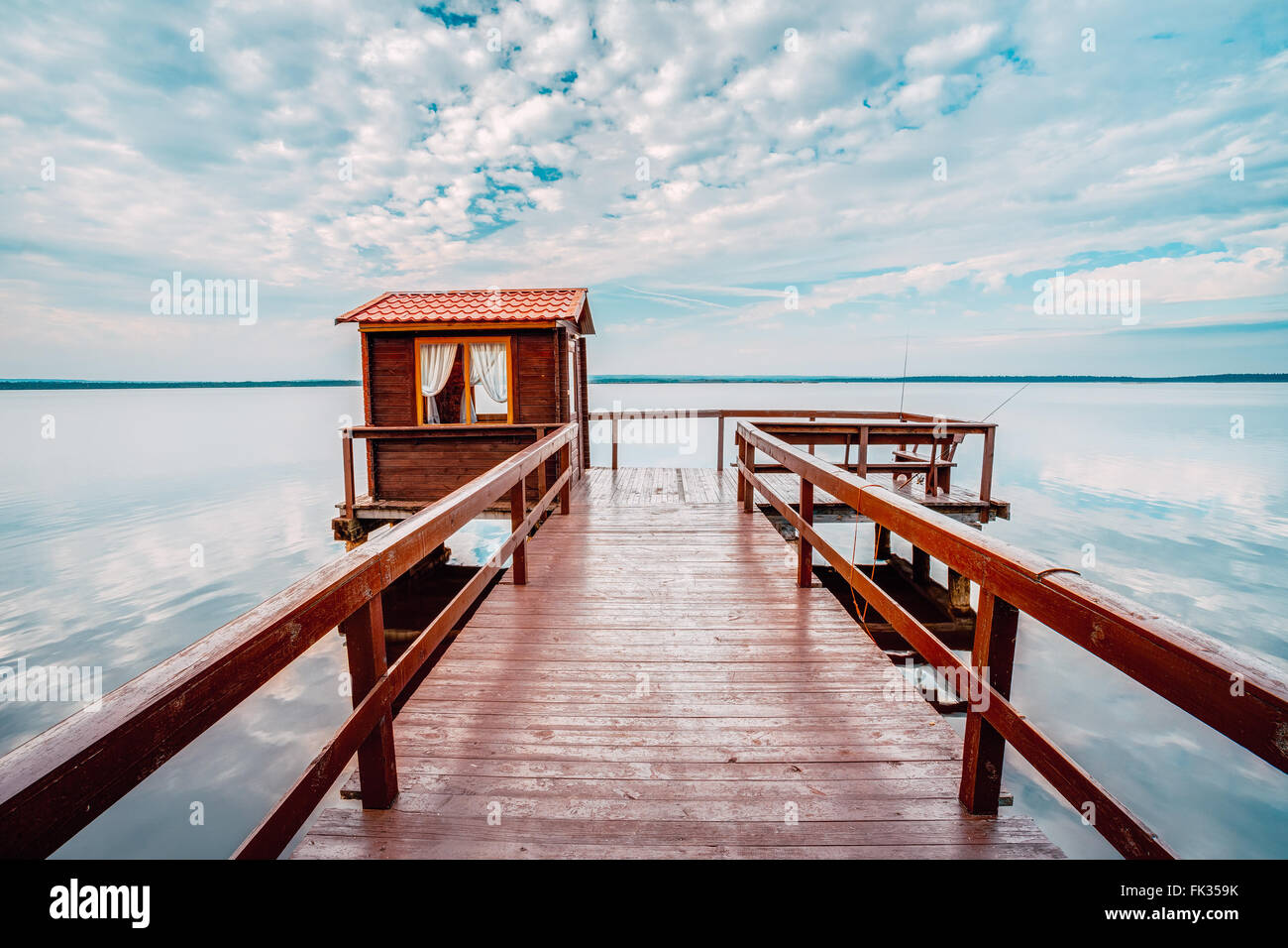 Old wooden pier for fishing, small house shed and beautiful lake or ...