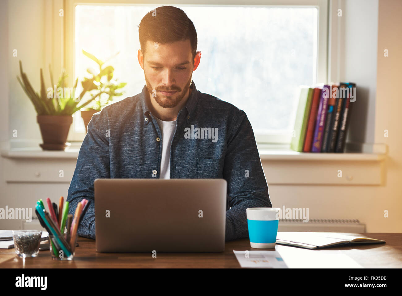 Entrepreneur working at a laptop computer typing or browsing the ...
