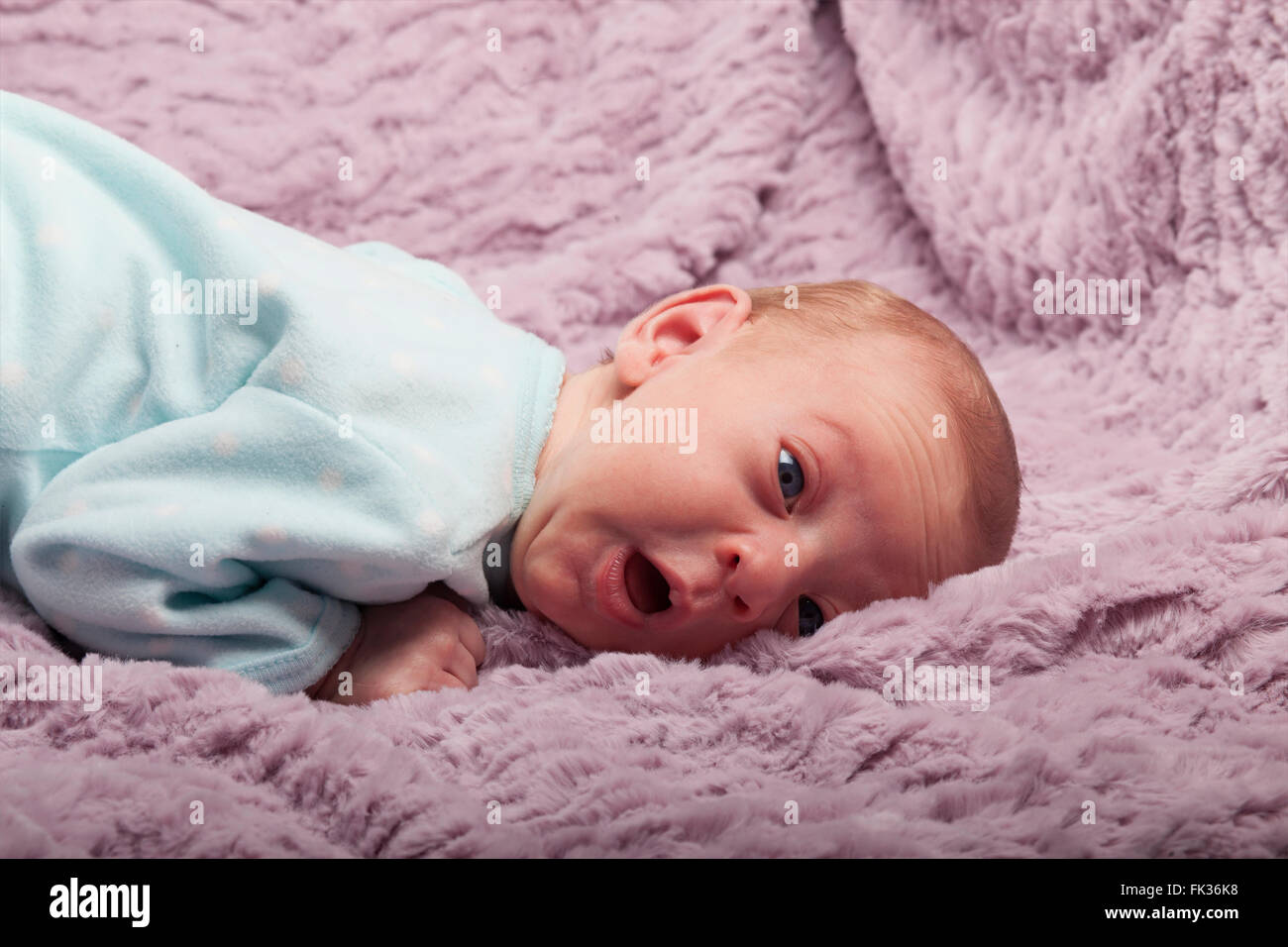 Adorable newborn baby on her side with funny expression Stock Photo - Alamy