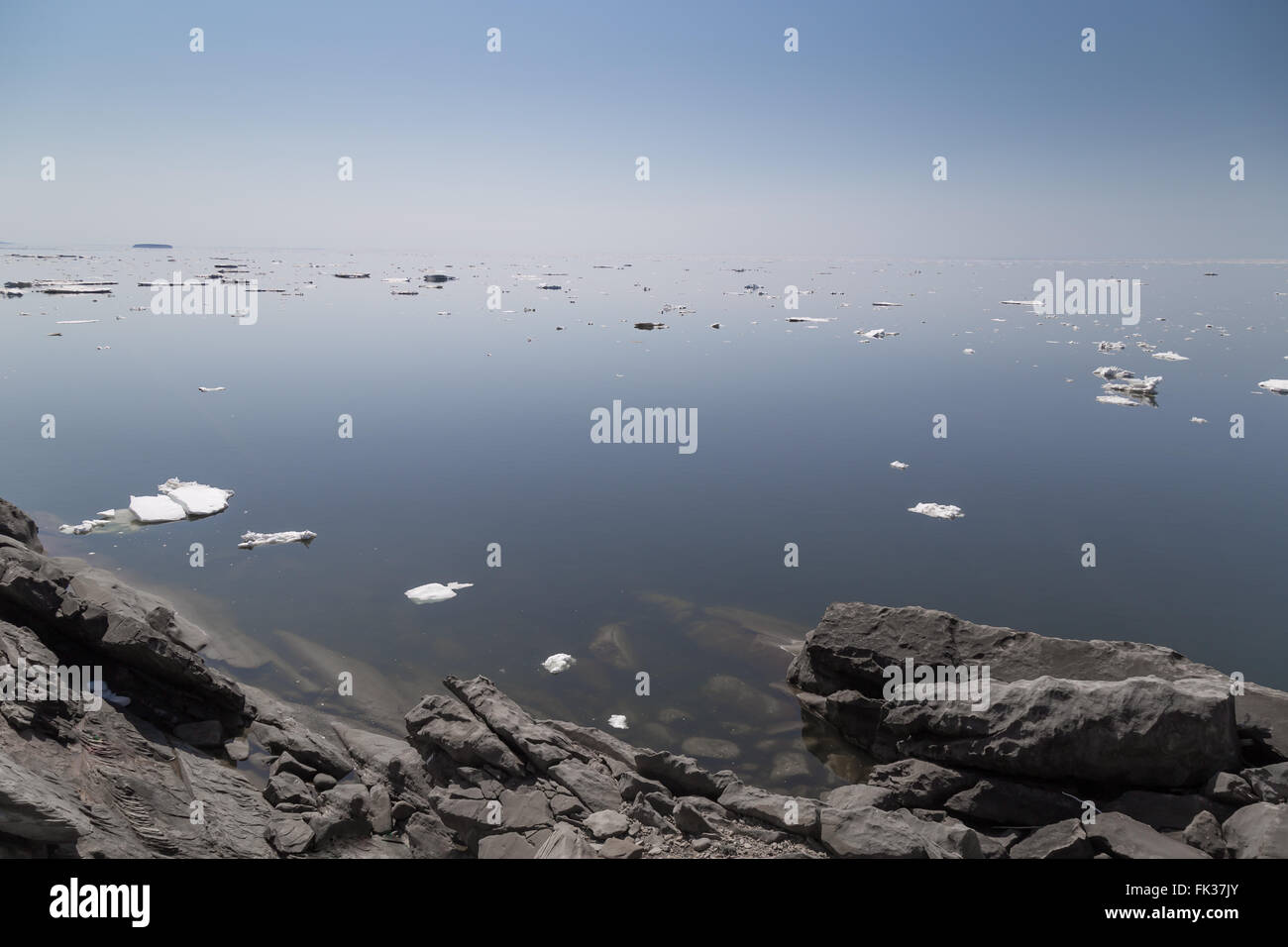 A disappearing horizon, grey rocks, and floating chunks of ice and snow ...