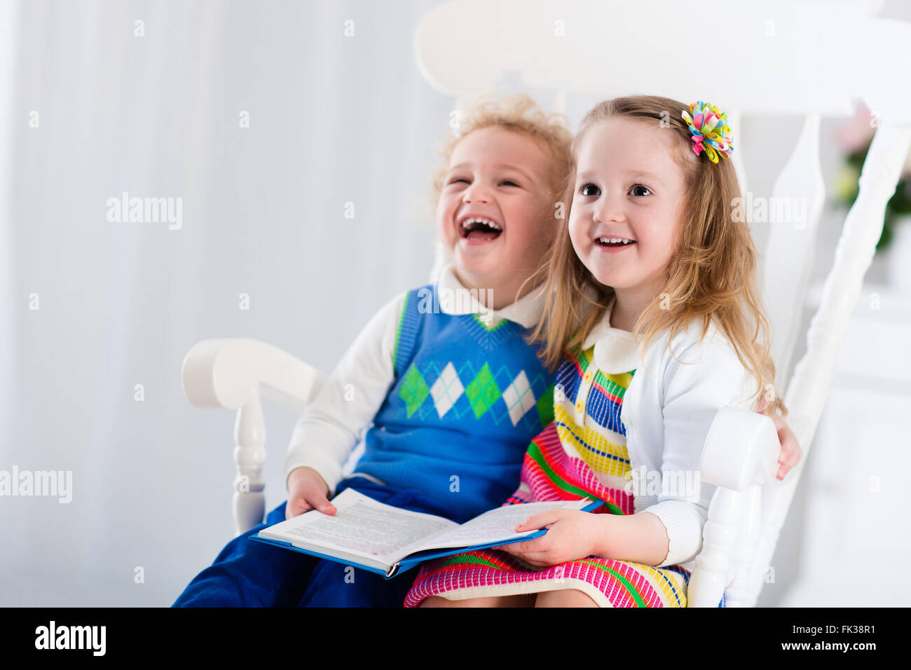 Kids read a book. Children reading books in white chair. Toddler kid ...