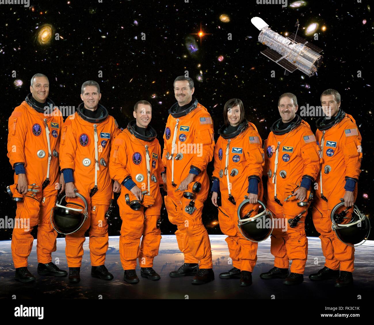 Group portrait of the STS-125 space shuttle crew astronauts in orange ...