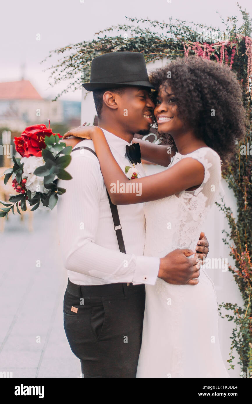 Happy african wedding couple hugs on the rooftop Stock Photo - Alamy