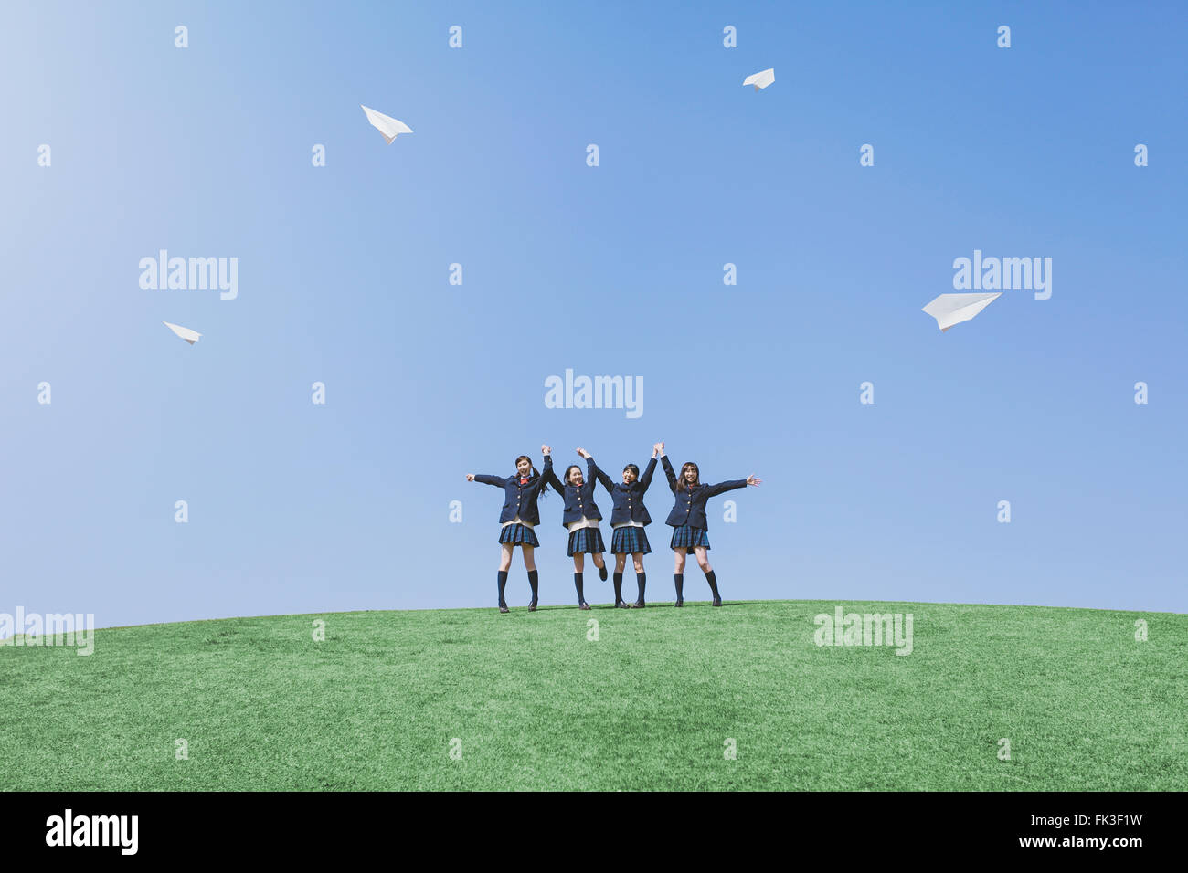 Japanese high school students flying paper planes in a city park Stock ...