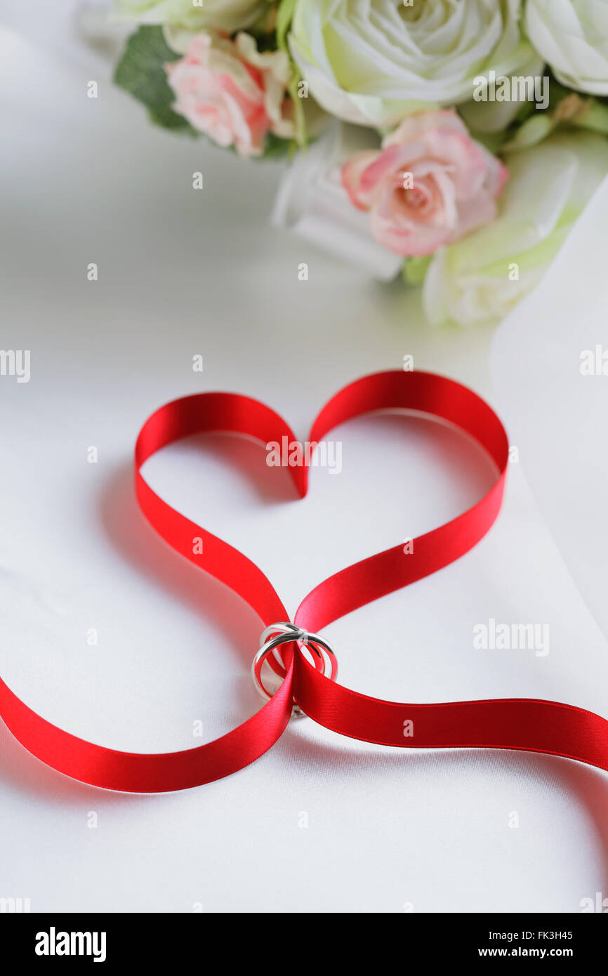 Red ribbon and wedding rings Stock Photo - Alamy