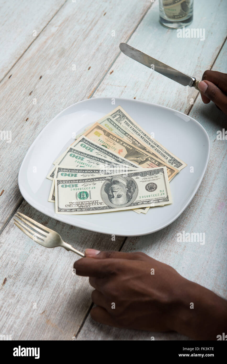 hand eating banknotes symbolising consumerism and corruption Stock ...