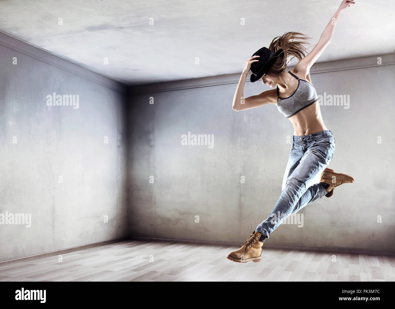Athletic young dancer jumping on a concrete wall background Stock Photo ...