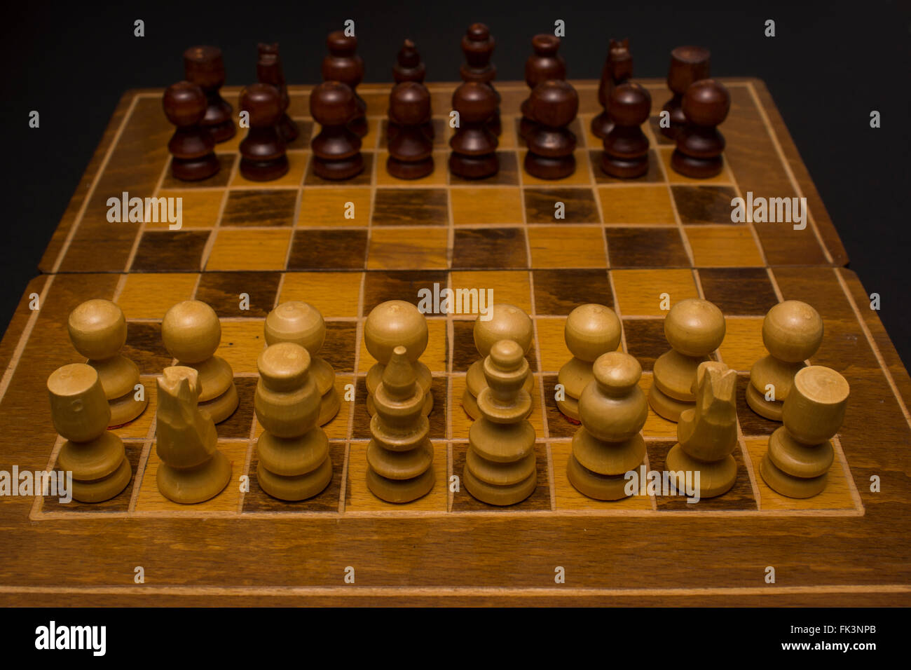 Light and dark wooden chess pieces on chess table. High resolution ...