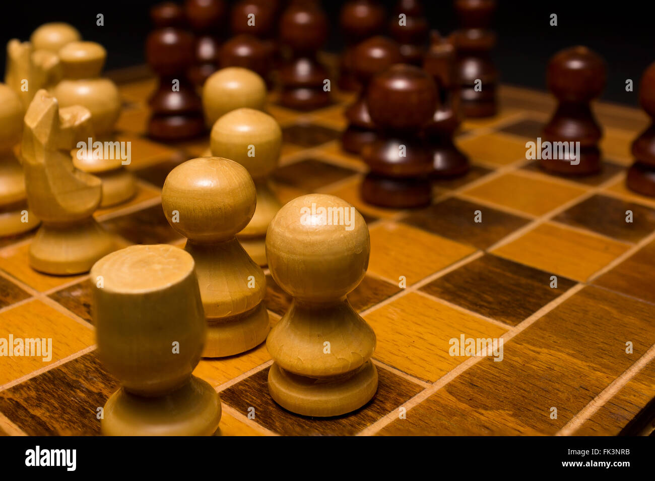 Light and dark wooden chess pieces on chess table. High resolution ...