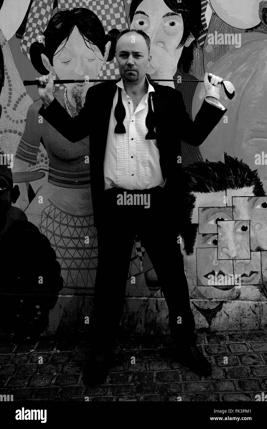 Man in DJ with golf club over shoulders in black and white Stock Photo ...