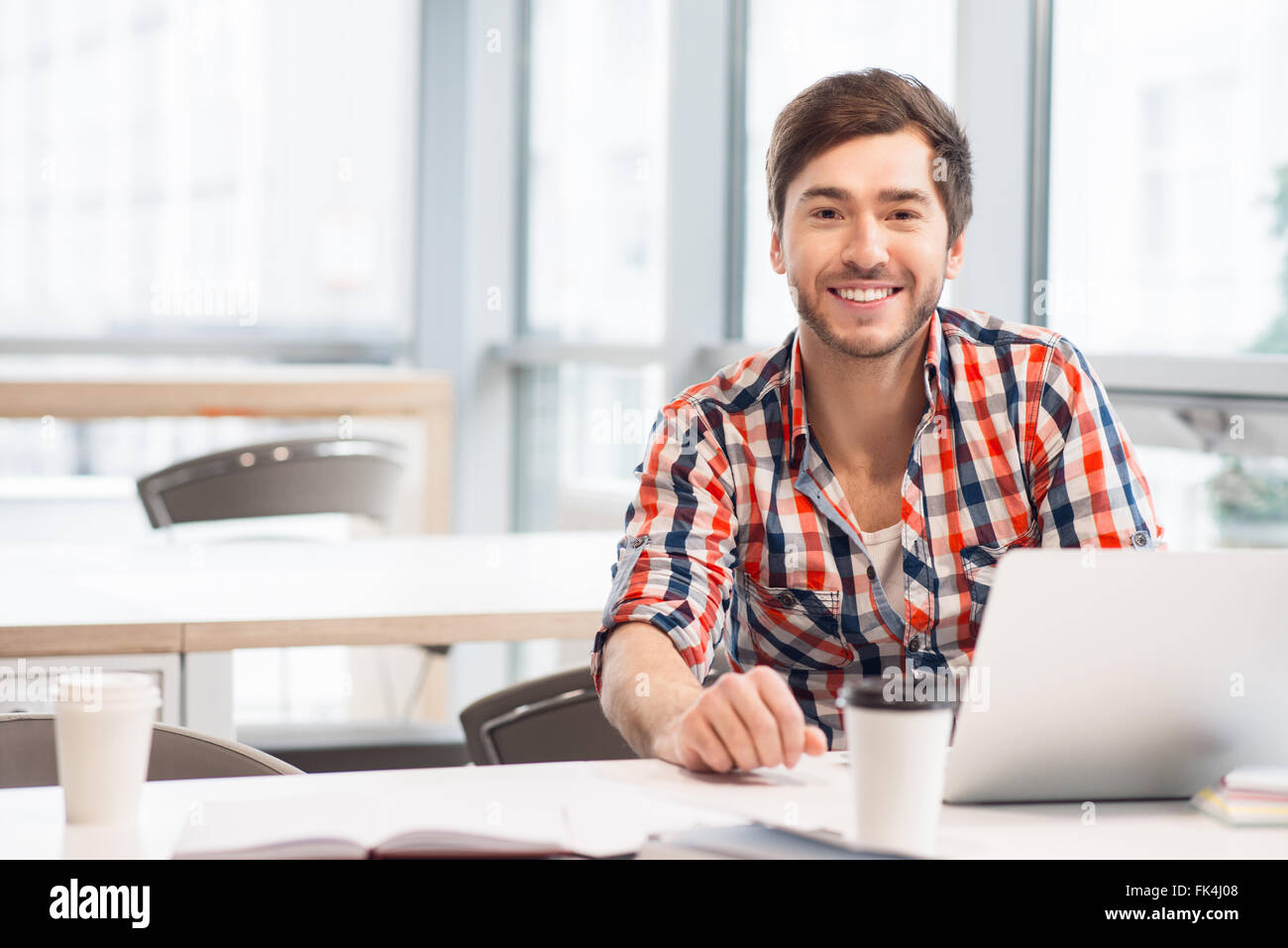 Smiling man sitting at the table Stock Photo - Alamy