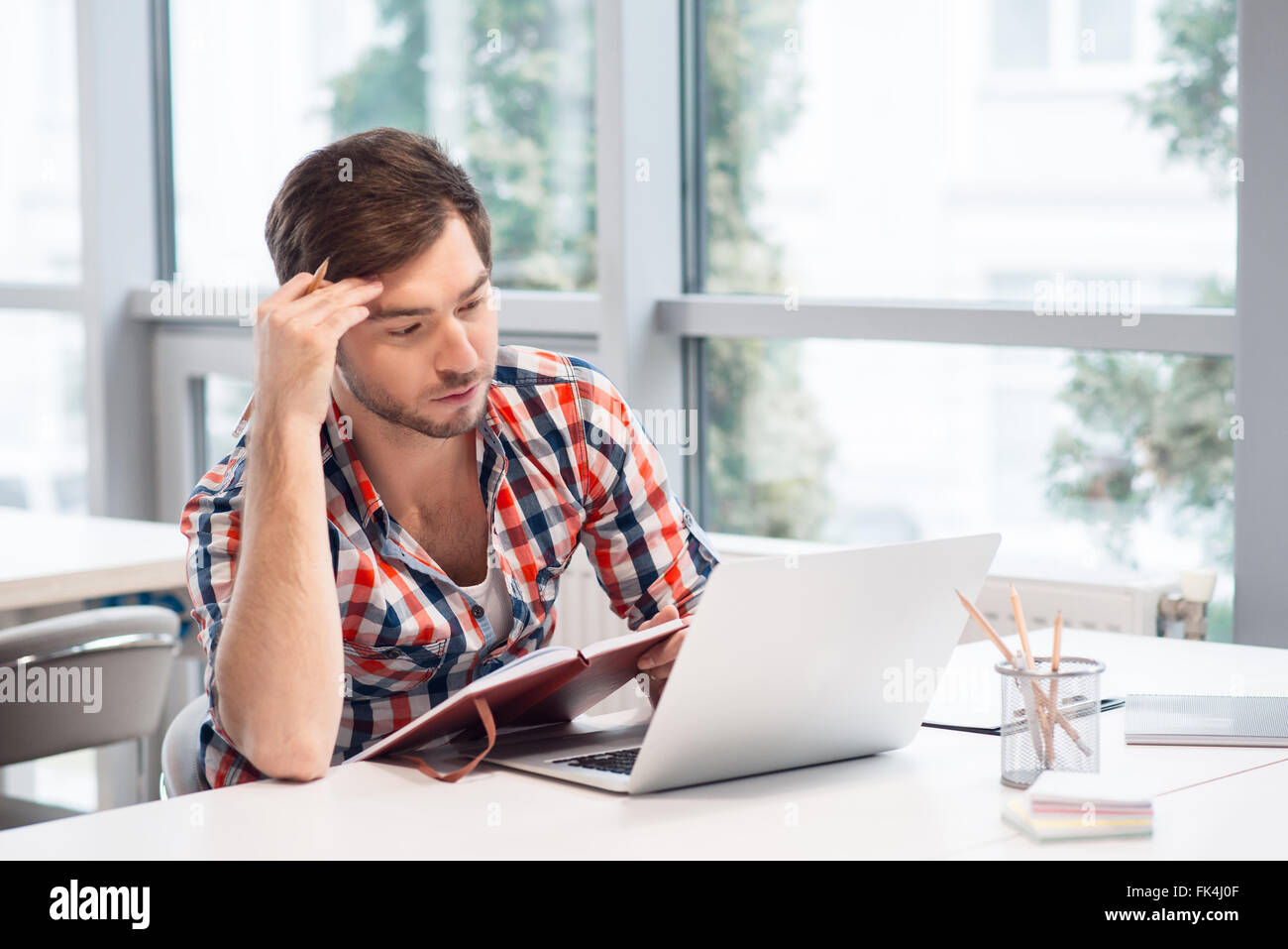 Handsome man sitting at the table Stock Photo - Alamy
