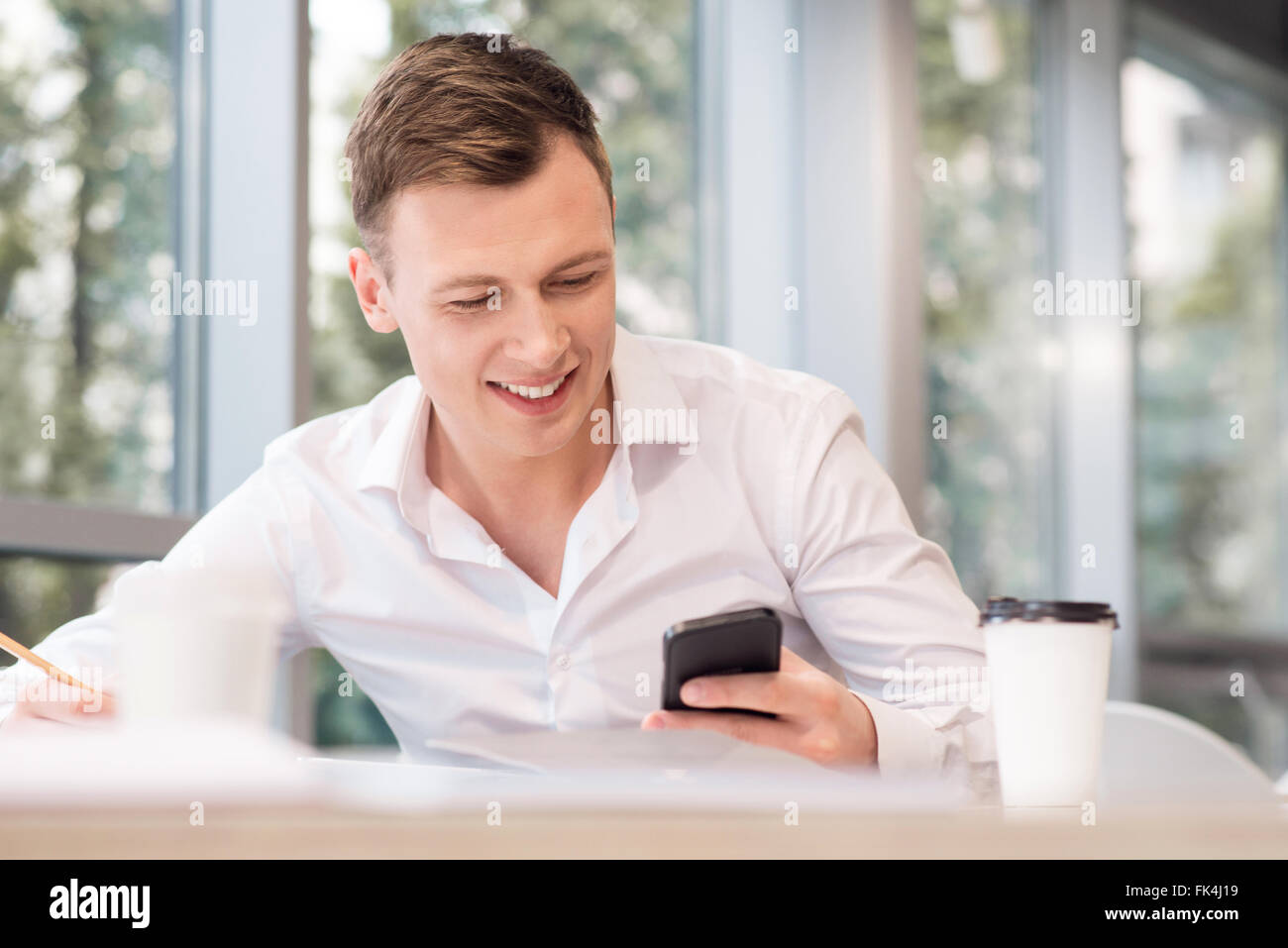 Pleasant man holding cell phone Stock Photo - Alamy