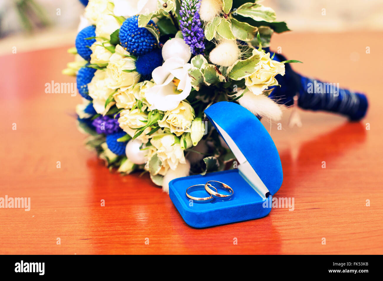 wedding rings in a blue box and a bridal bouquet Stock Photo - Alamy