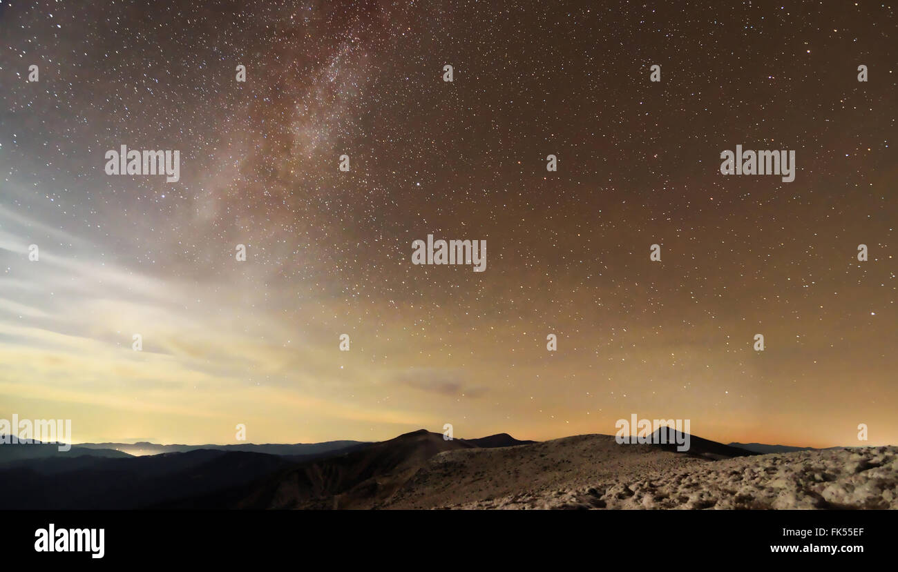 Milky Way over mountains with clouds and moon light Stock Photo - Alamy