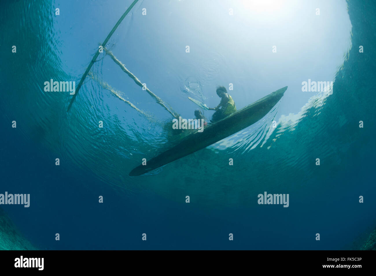 Papuan outrigger dugout canoe looms overhead in the reef underwater ...