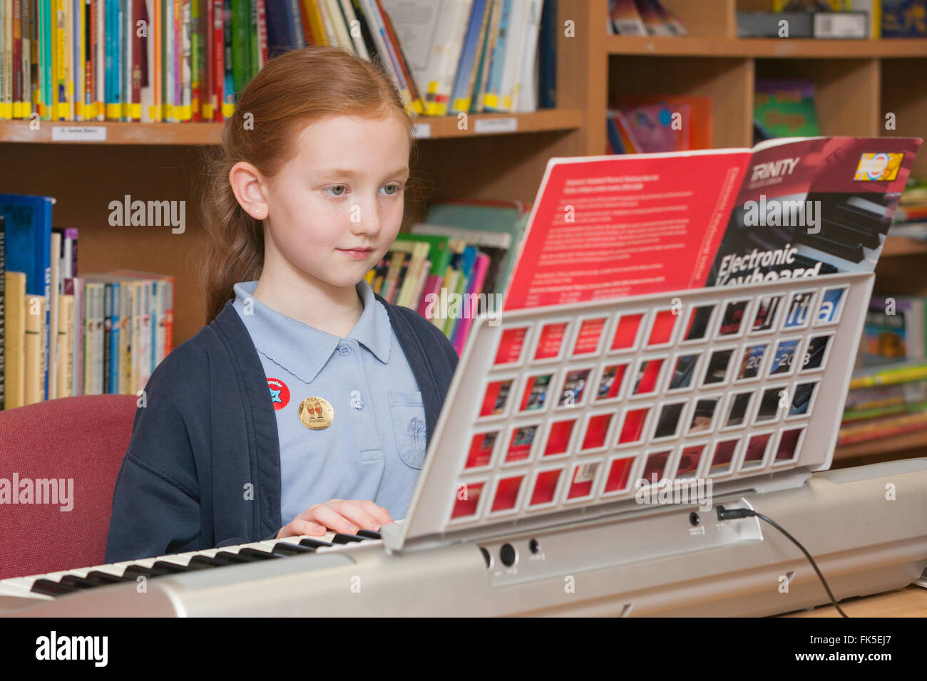A pupil in school uniform at a Primary School in the UK playing an ...