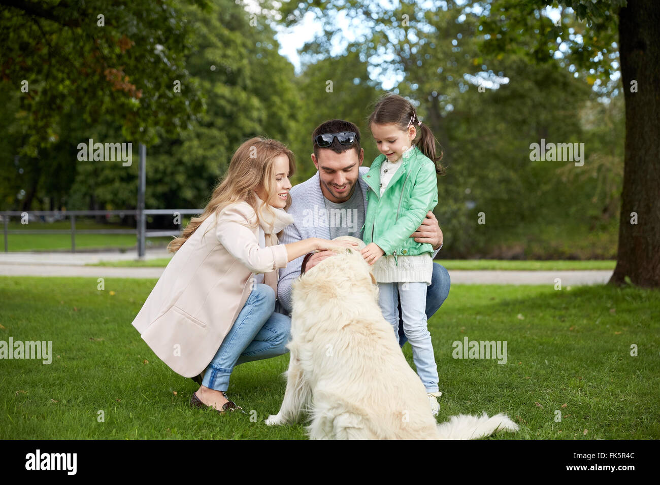 happy family with labrador retriever dog in park Stock Photo - Alamy