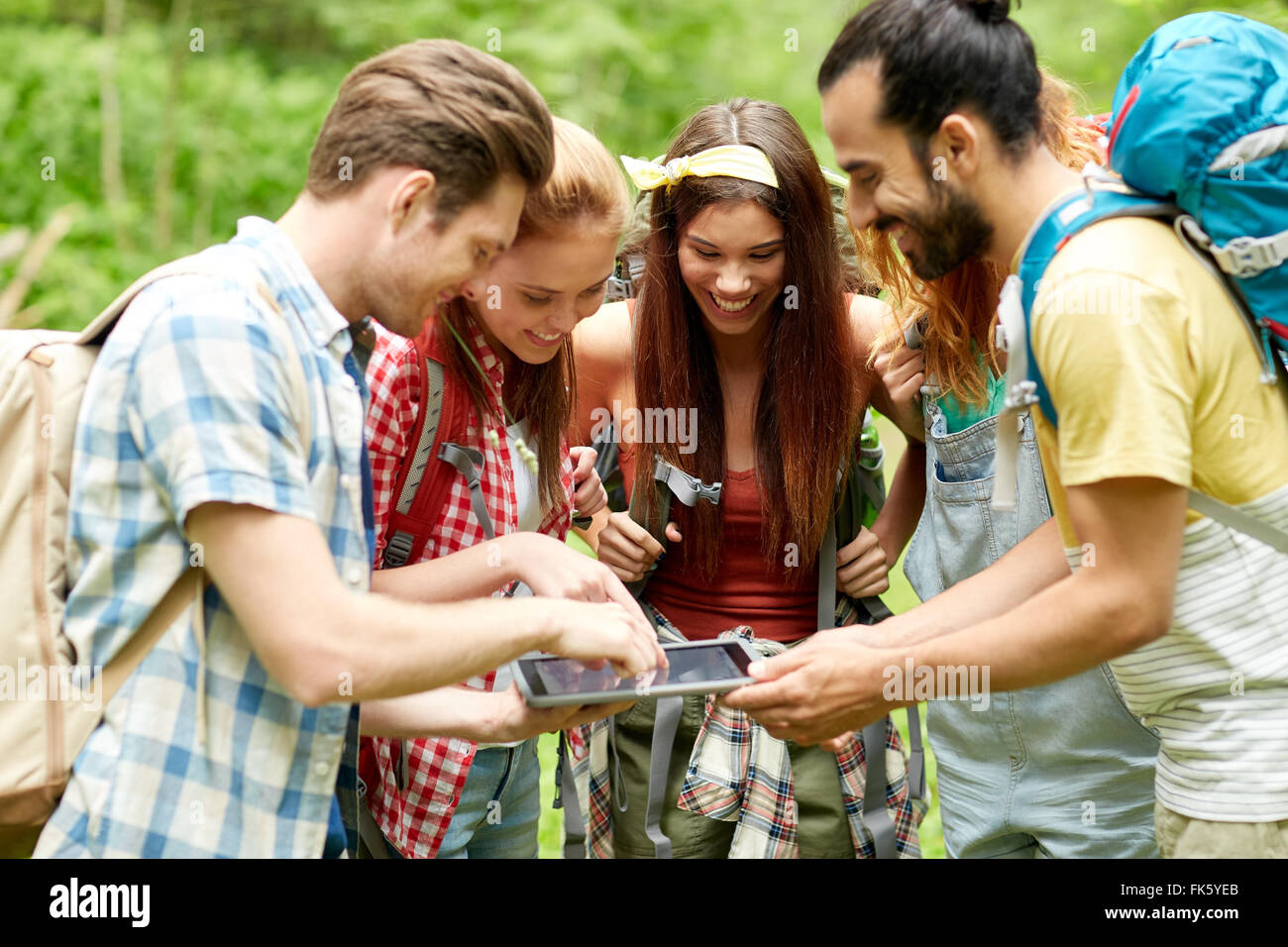 happy friends with backpacks and tablet pc hiking Stock Photo - Alamy