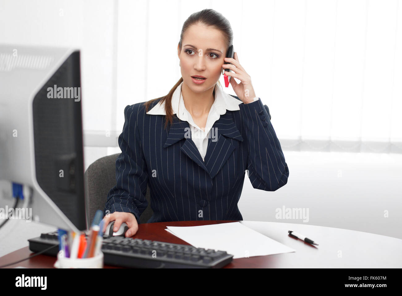 Young brunette accountant calling client in office Stock Photo - Alamy