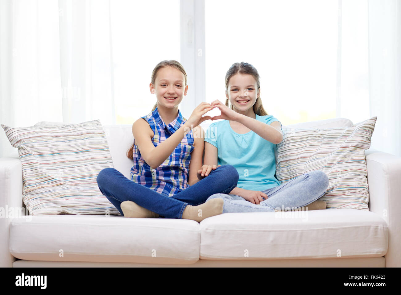 happy little girls showing heart shape hand sign Stock Photo - Alamy
