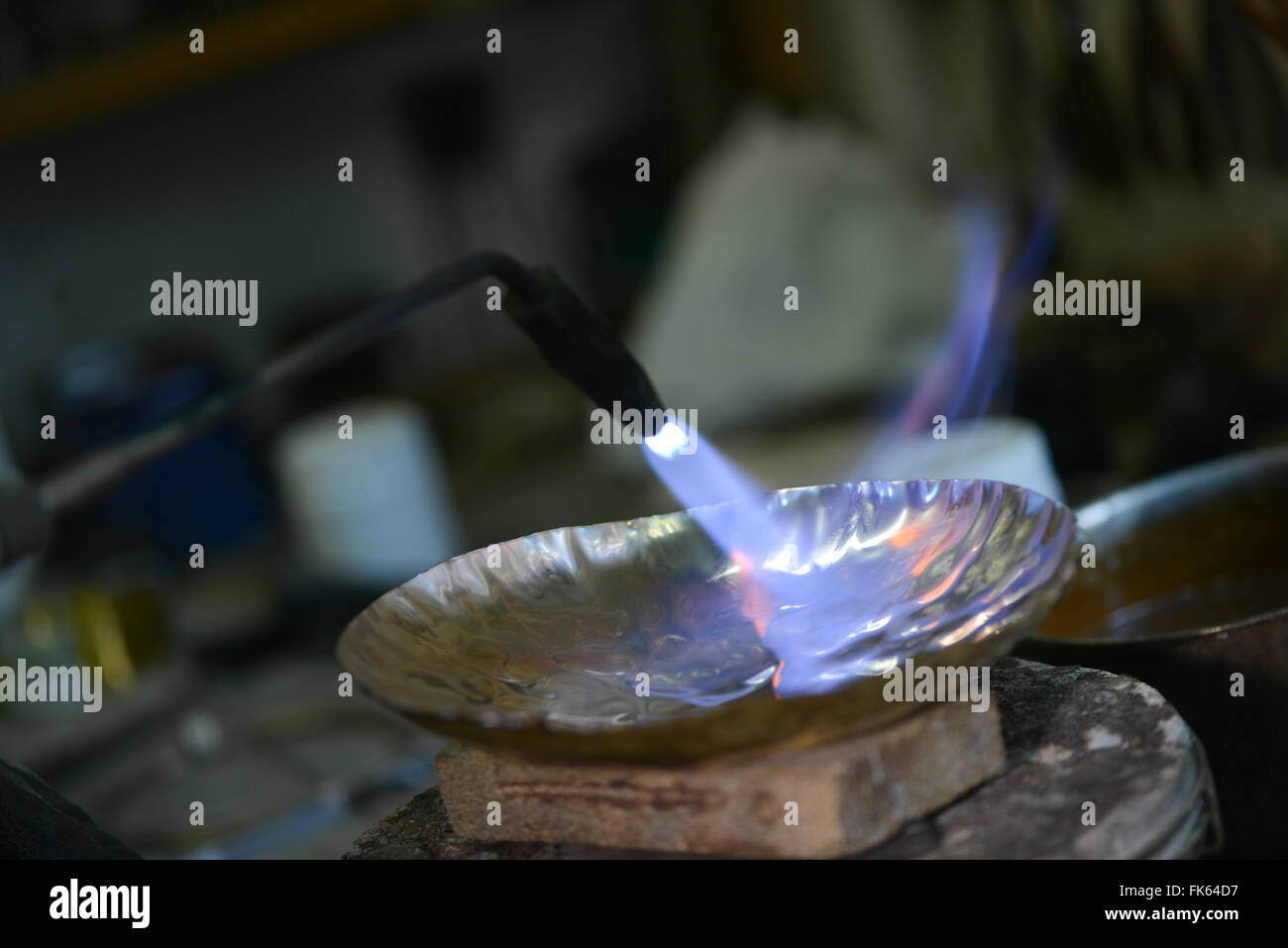 Master goldsmith working with silver-Annealing the metal to make it ...
