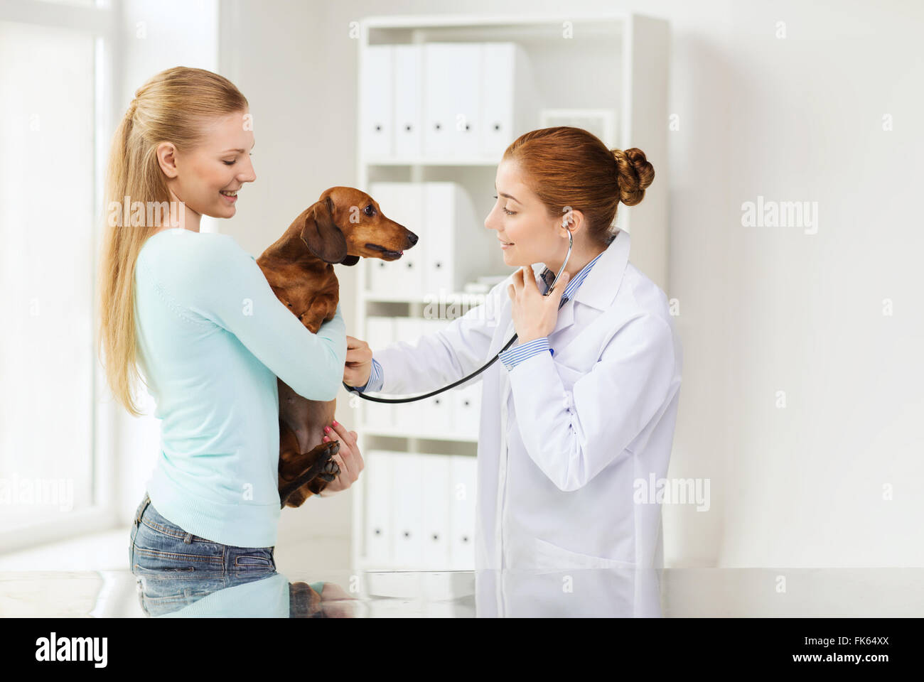 happy woman with dog and doctor at vet clinic Stock Photo - Alamy