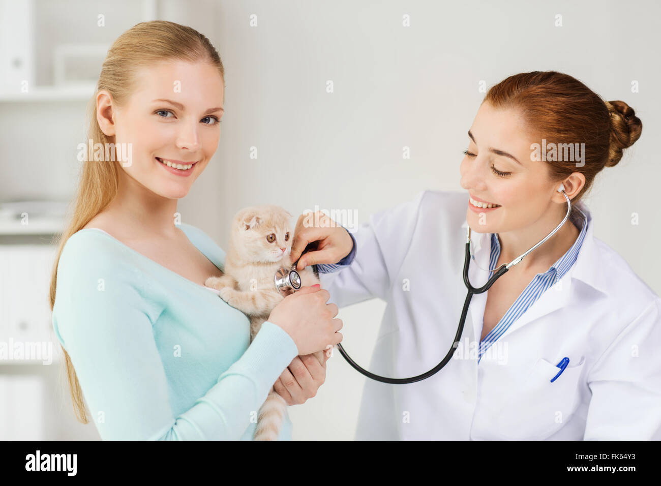 happy woman with cat and doctor at vet clinic Stock Photo - Alamy
