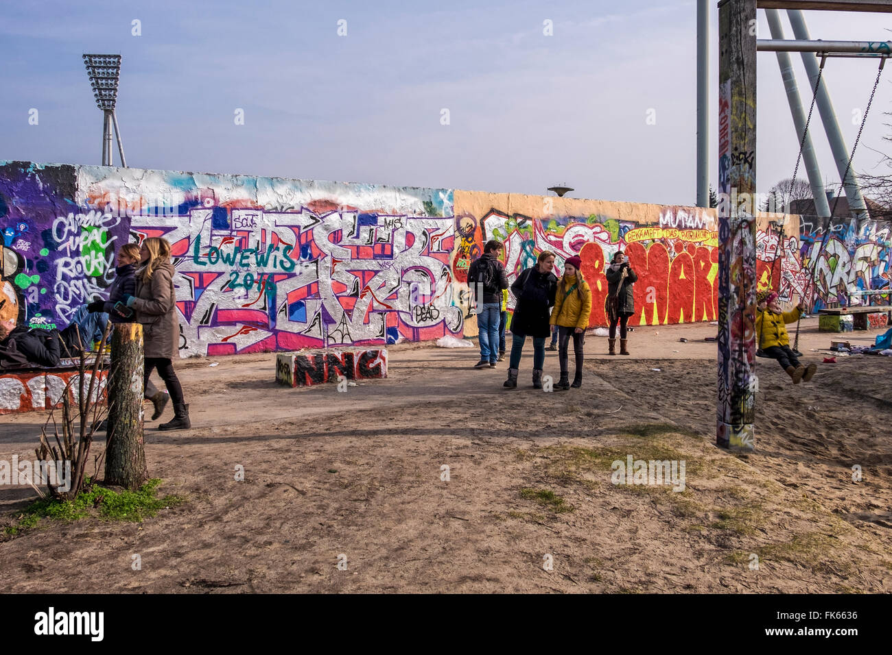 Tourists walk past graffiti covered Berlin wall at Mauerpark, Berlin ...